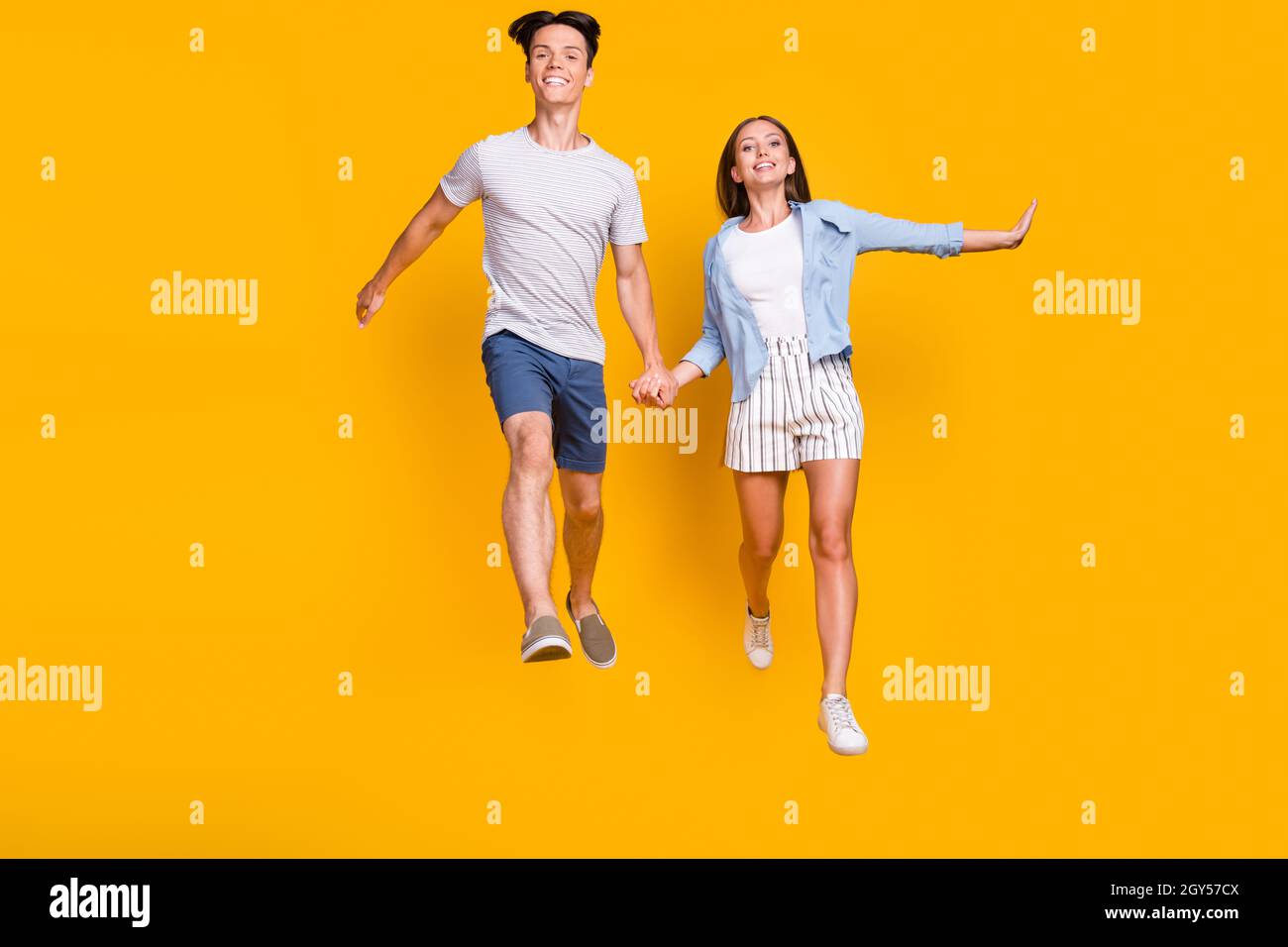 Full length body size view of nice cheerful couple jumping running trip ...