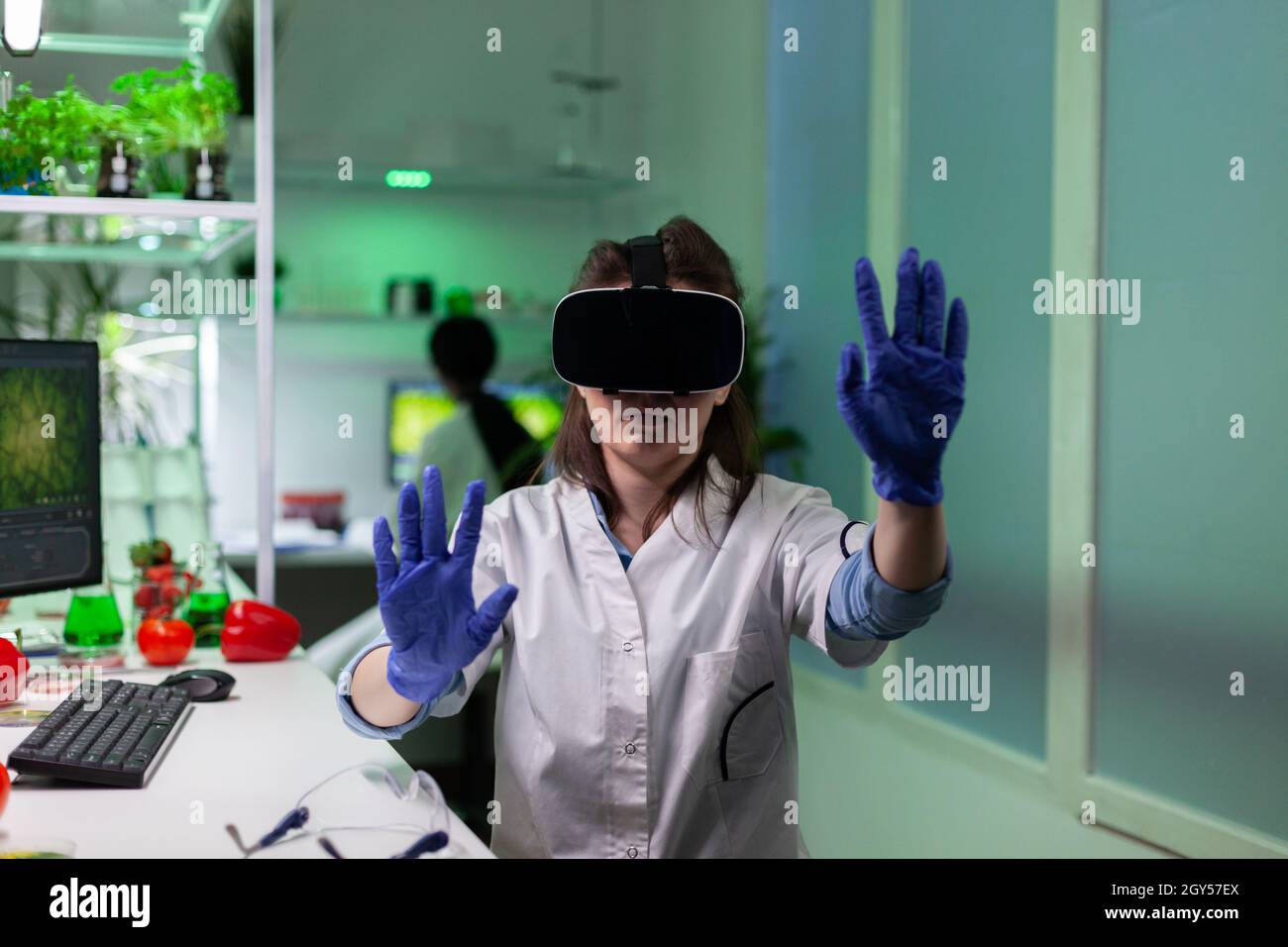 Biologist researcher woman wearing virtual reality headphones analyzing ...