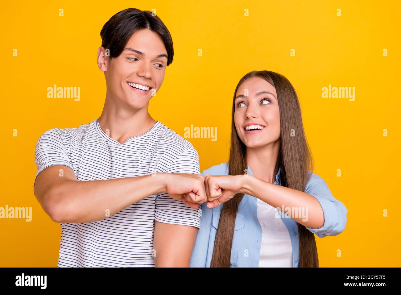 Portrait of attractive cheerful couple partners touching fists support ...