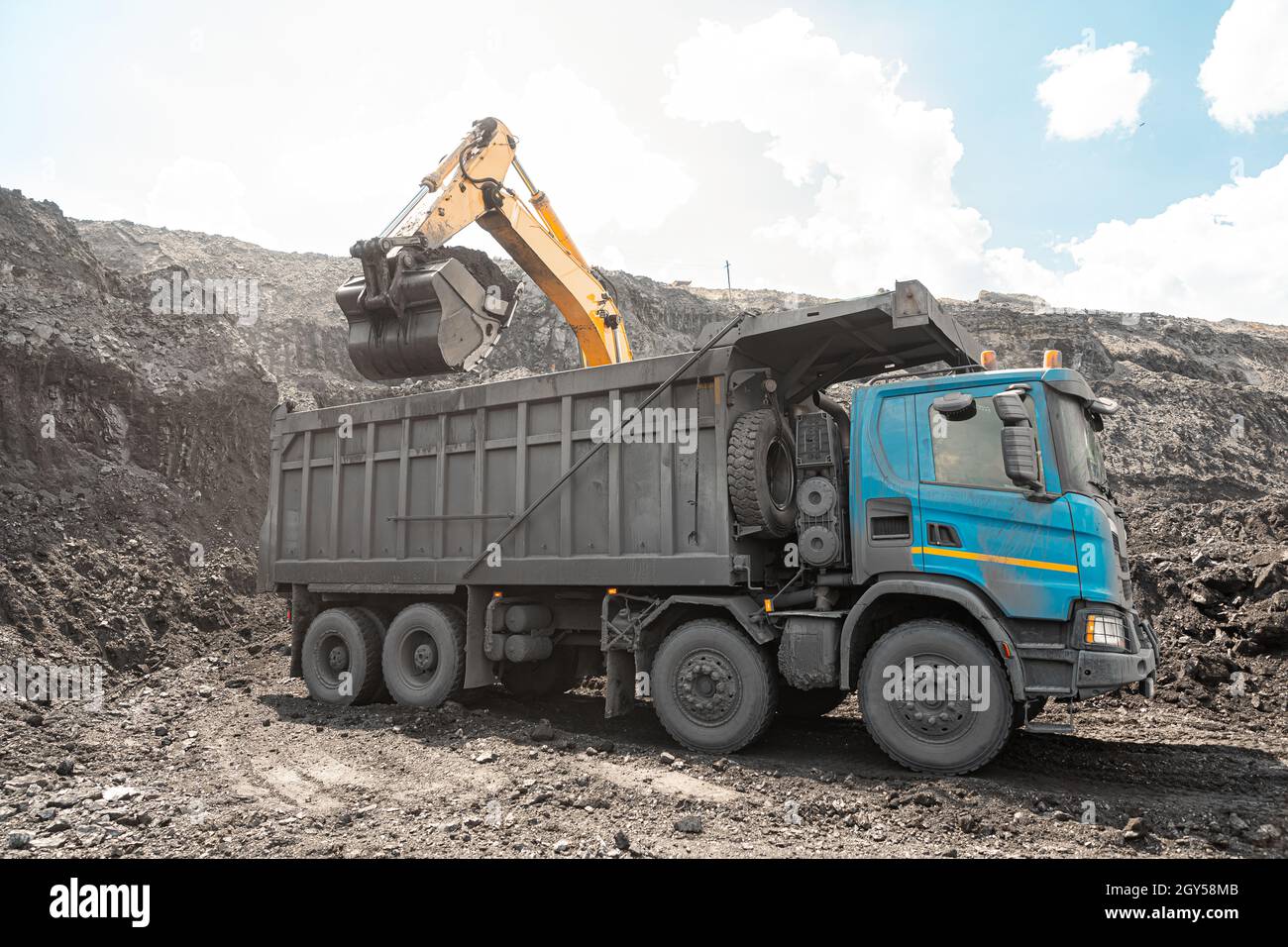Large quarry dump truck. Loading the rock in dumper. Loading coal into ...