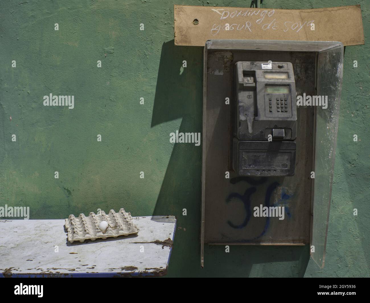 Old public telephone on a green wall Stock Photo - Alamy