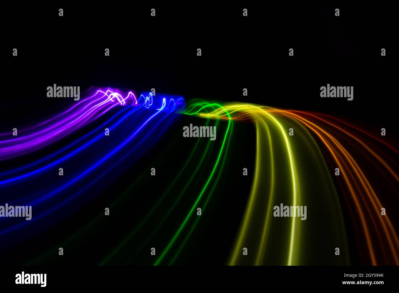 Lines with the colors of the rainbow on a black background. Lights with ...