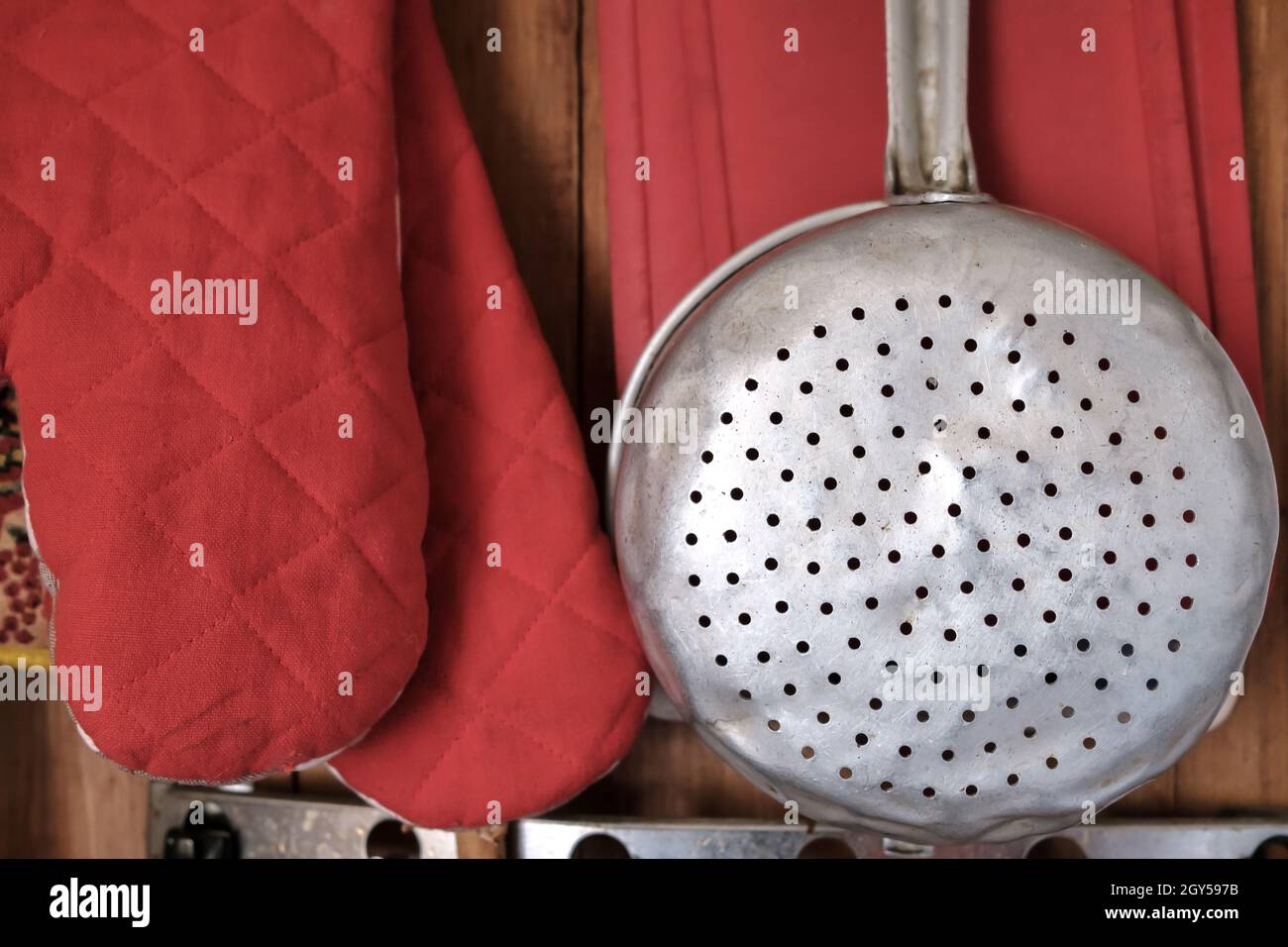 Aluminum colander hangs on the wall of a country house. Kitchen ...