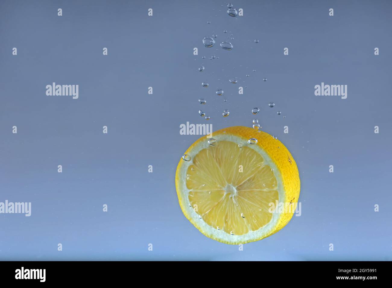 Lemon wedges falling into the water with splashing Stock Photo - Alamy