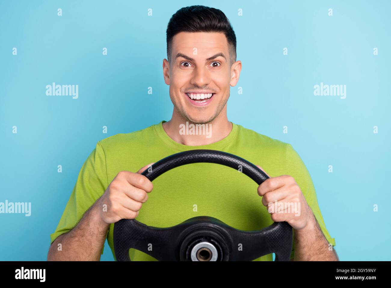 Photo of cheerful young amazed happy man hold hands steering wheel ...