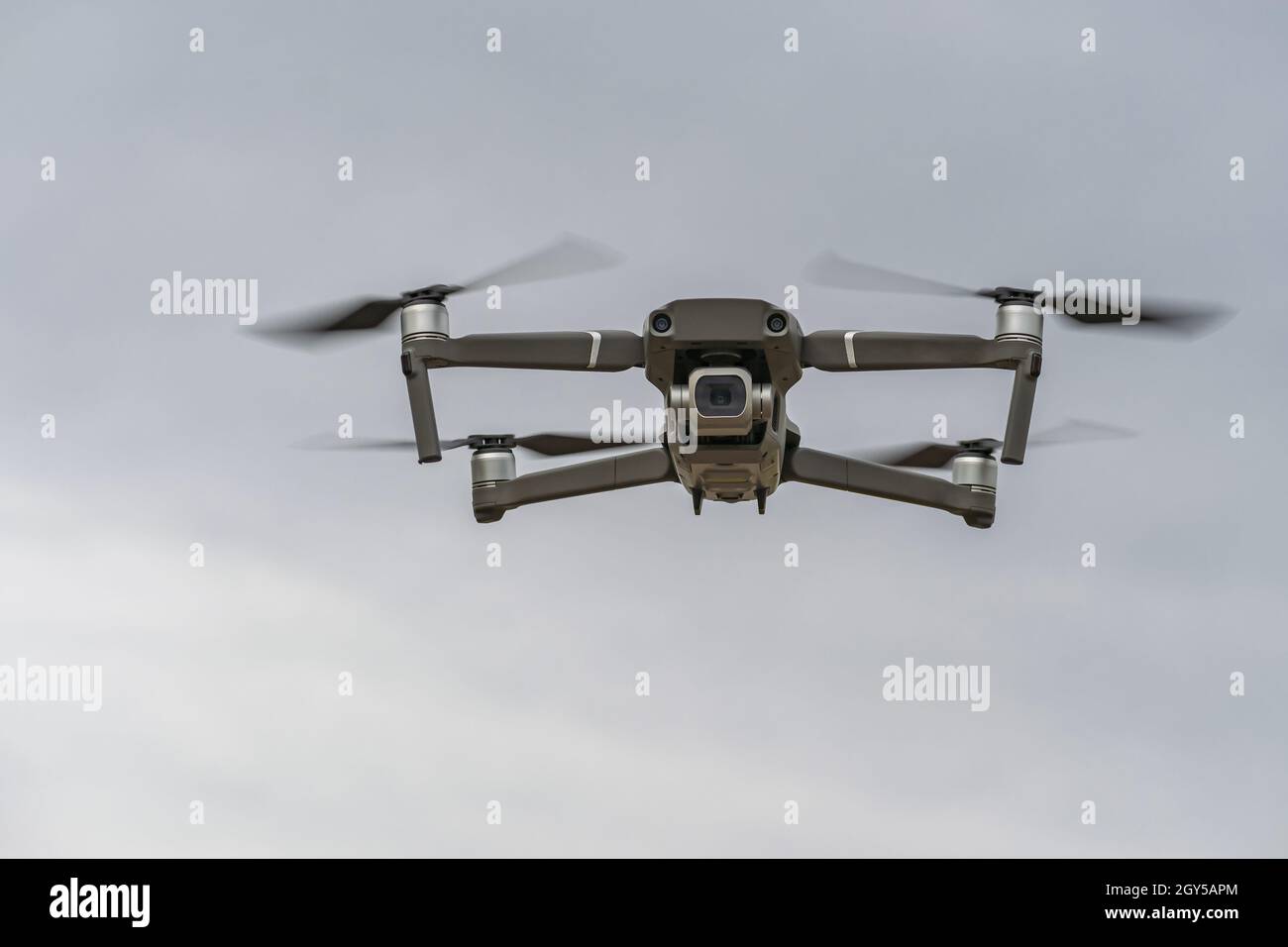 Professional quadcopter flying high in the gray sky Stock Photo - Alamy