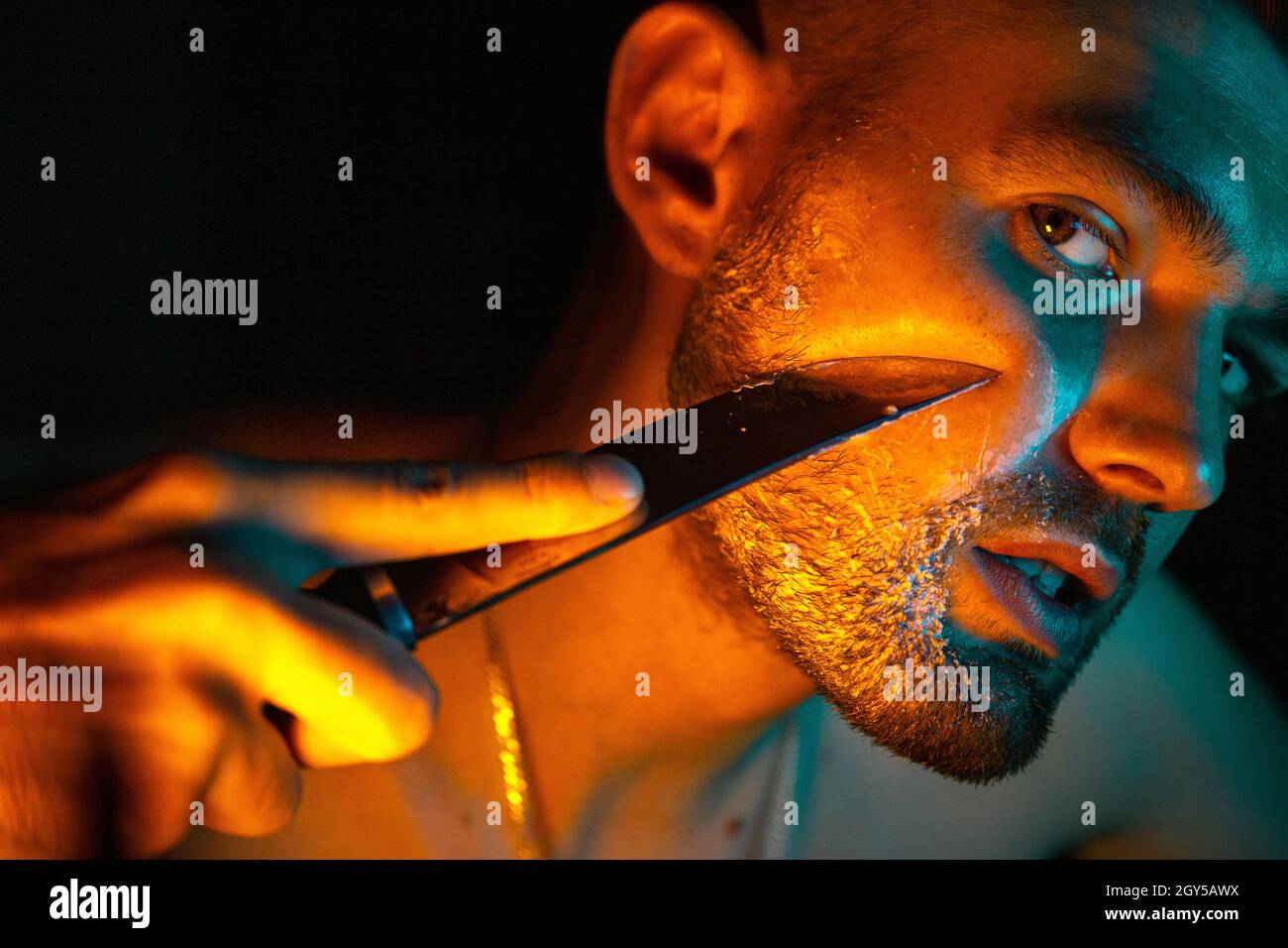 Male shaving with a large kitchen knife Stock Photo - Alamy