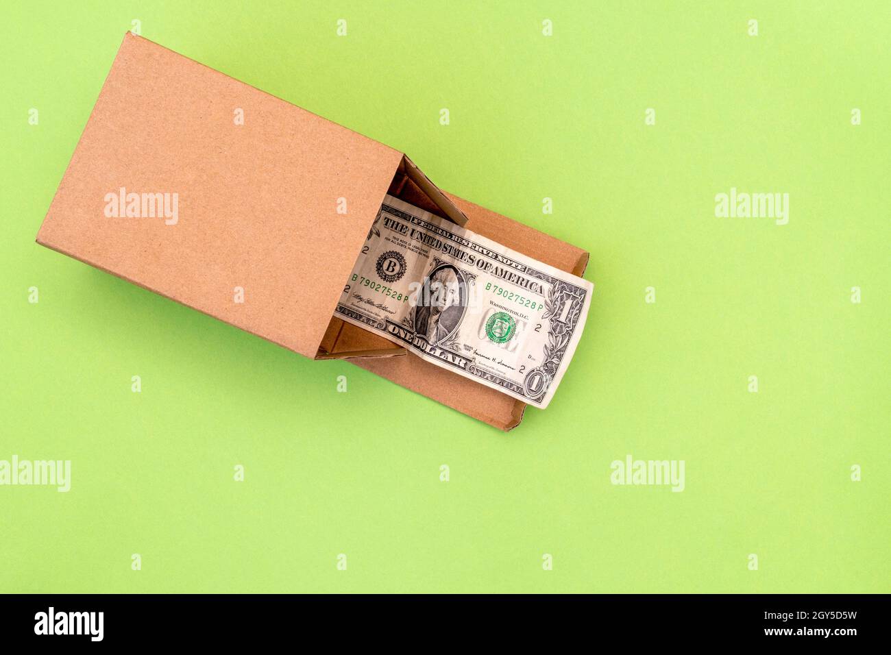 A dollar bulging out of a cardboard box. Financial concept Stock Photo ...