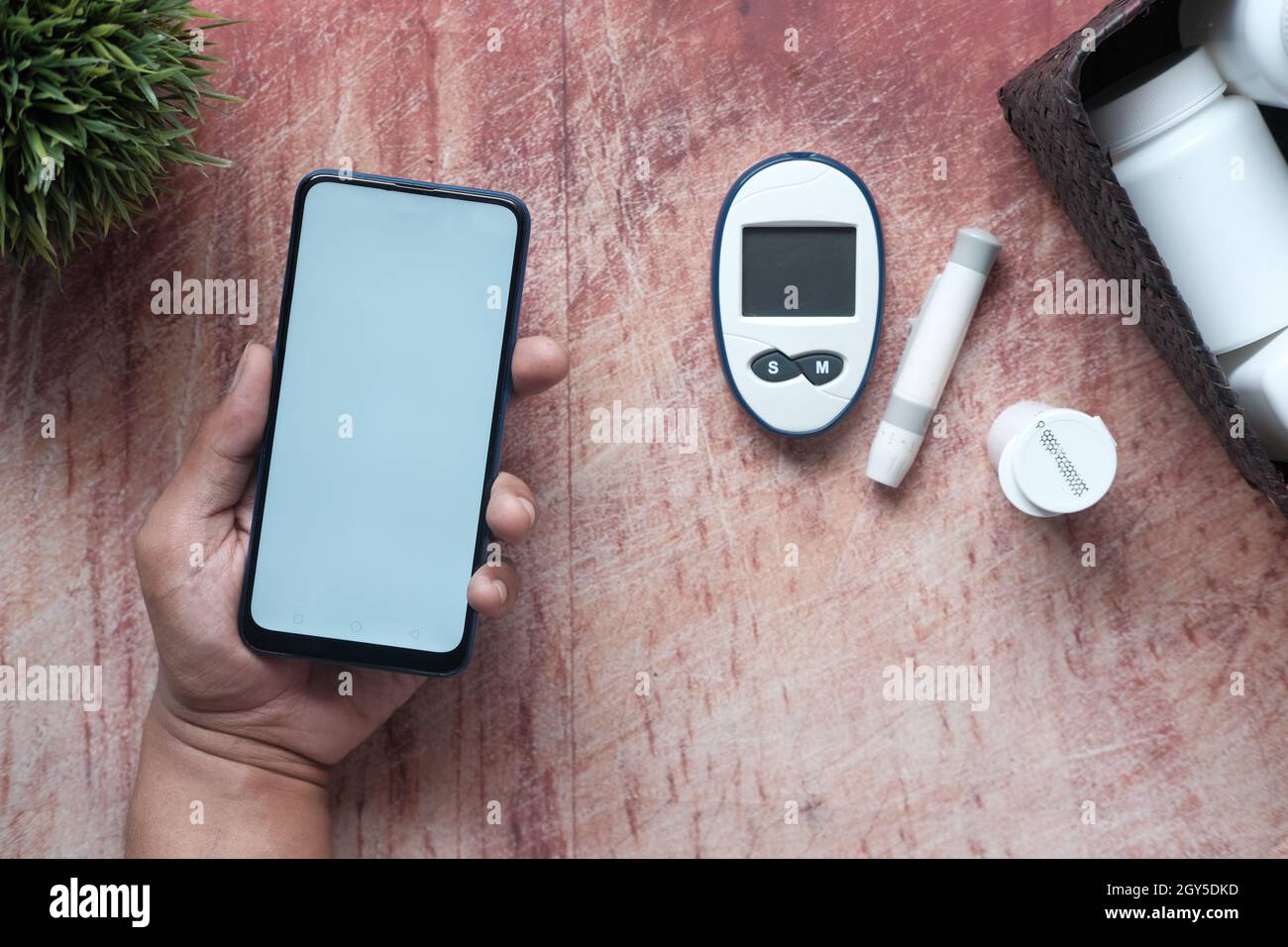 holding a smart phone and diabetic measurement tools on table Stock ...