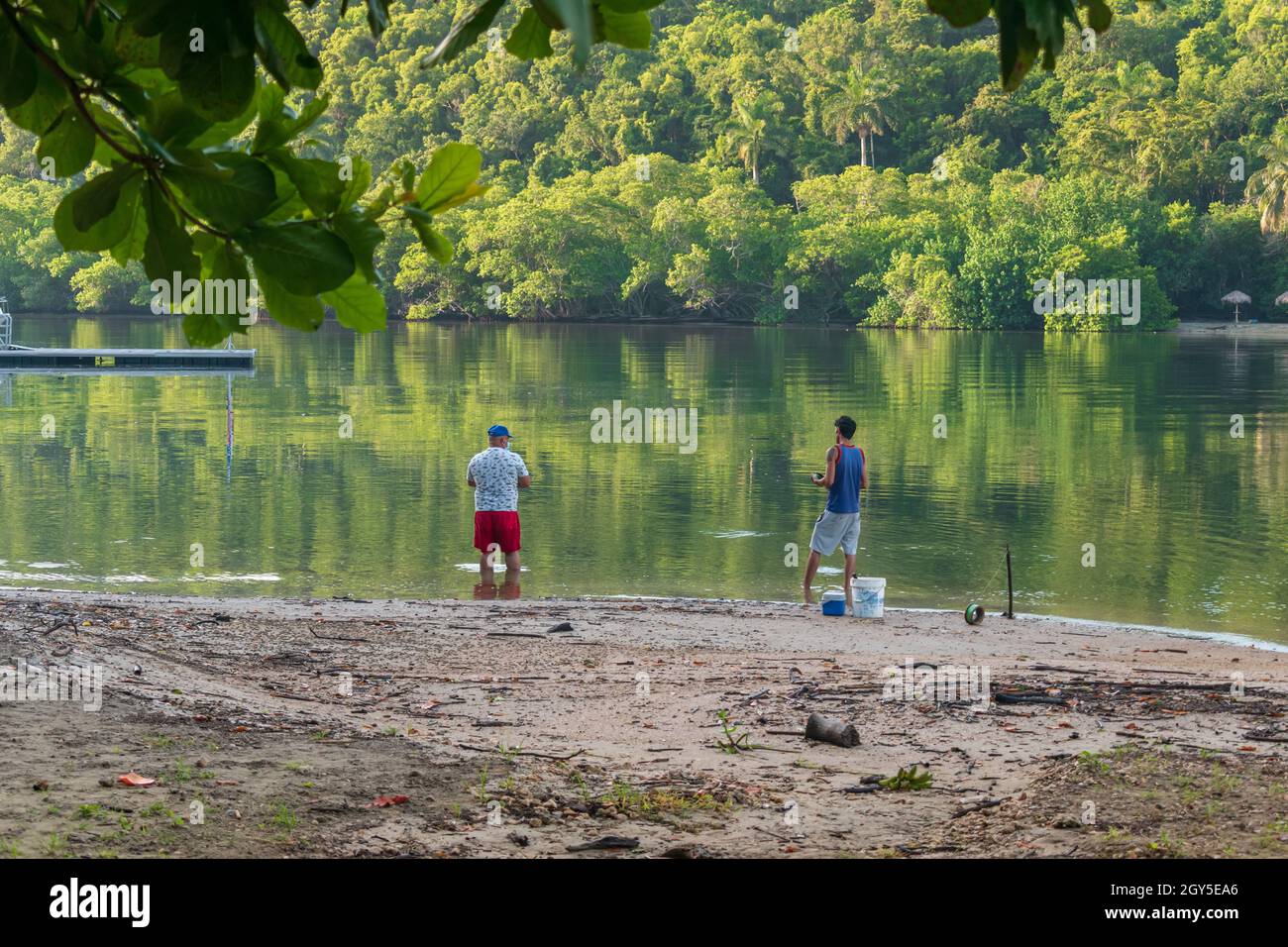 People catching fish in a lake surrounded by greenery Stock Photo - Alamy
