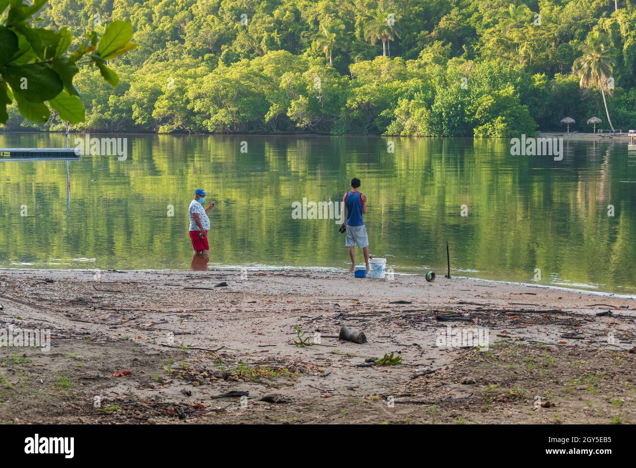 People catching fish in a lake surrounded by greenery Stock Photo - Alamy