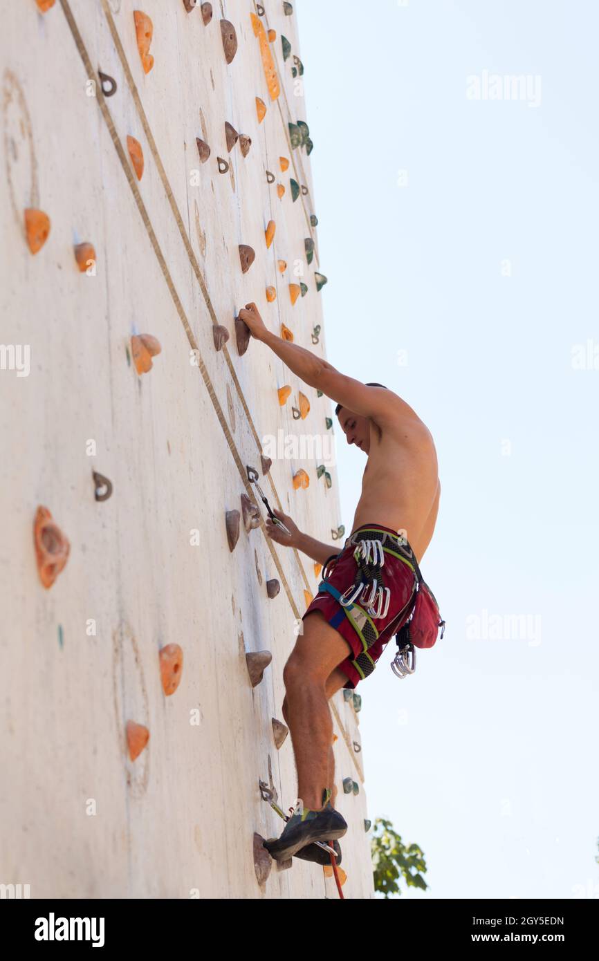 young man climbing in climbing wall, urban sport, summer, self ...
