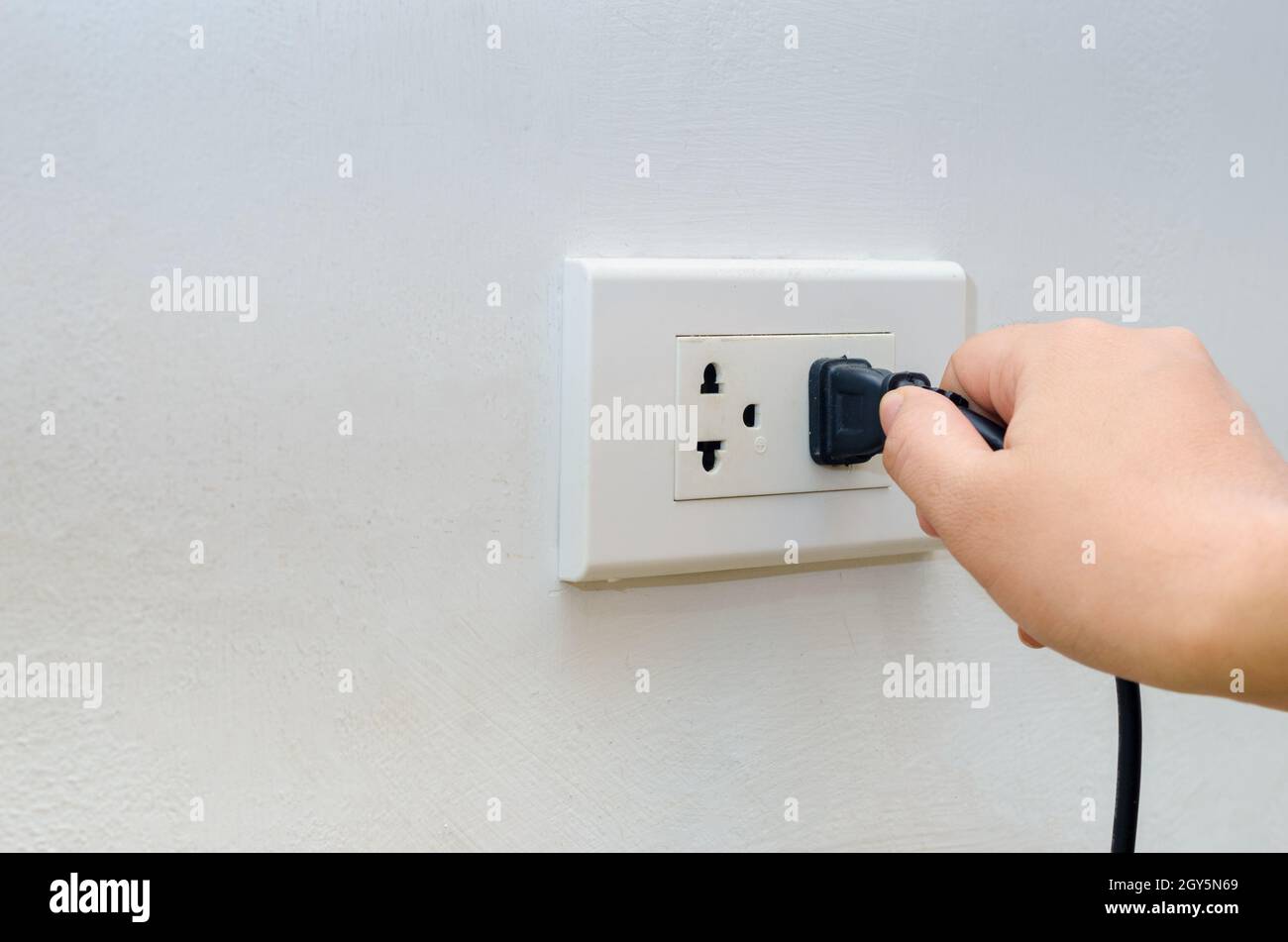 hand outlet Power saving Hand inserting electrical plug into outlet ...