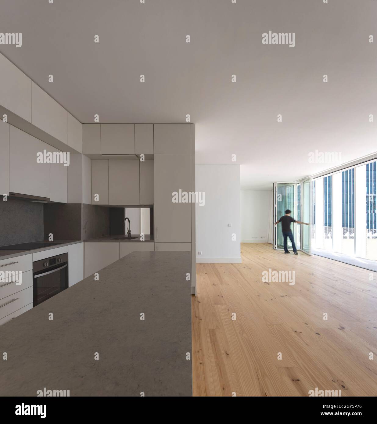 Kitchen view with figure opening concertina windows. Ribeira 11, Lisbon ...
