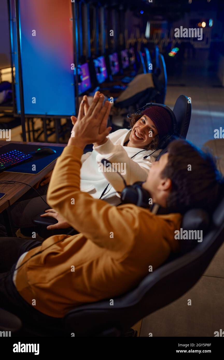 Two young gamers having fun in video game club. Virtual entertainment ...