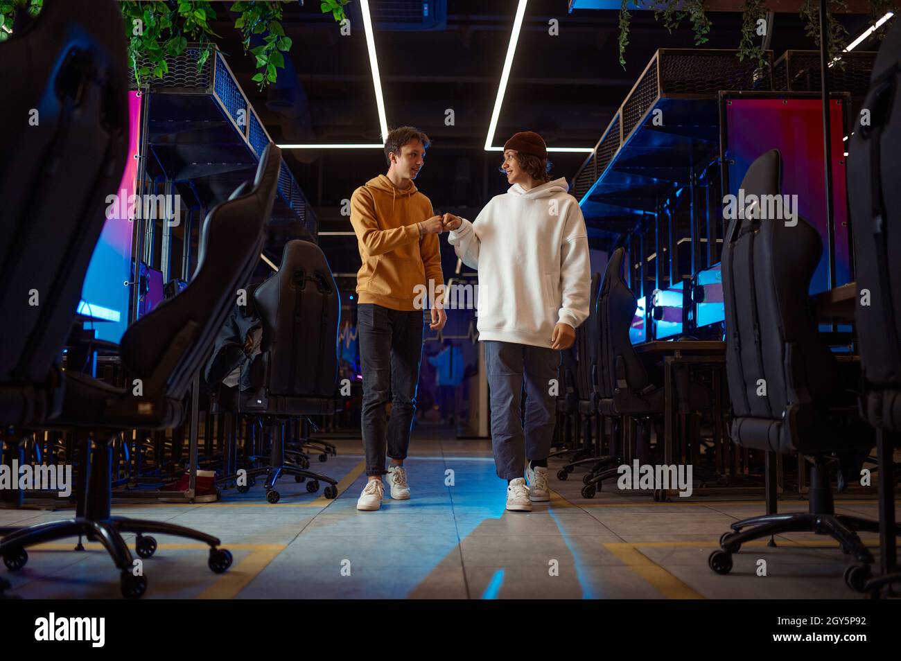 Two young gamers talking in game club. Virtual entertainment, e-sport ...