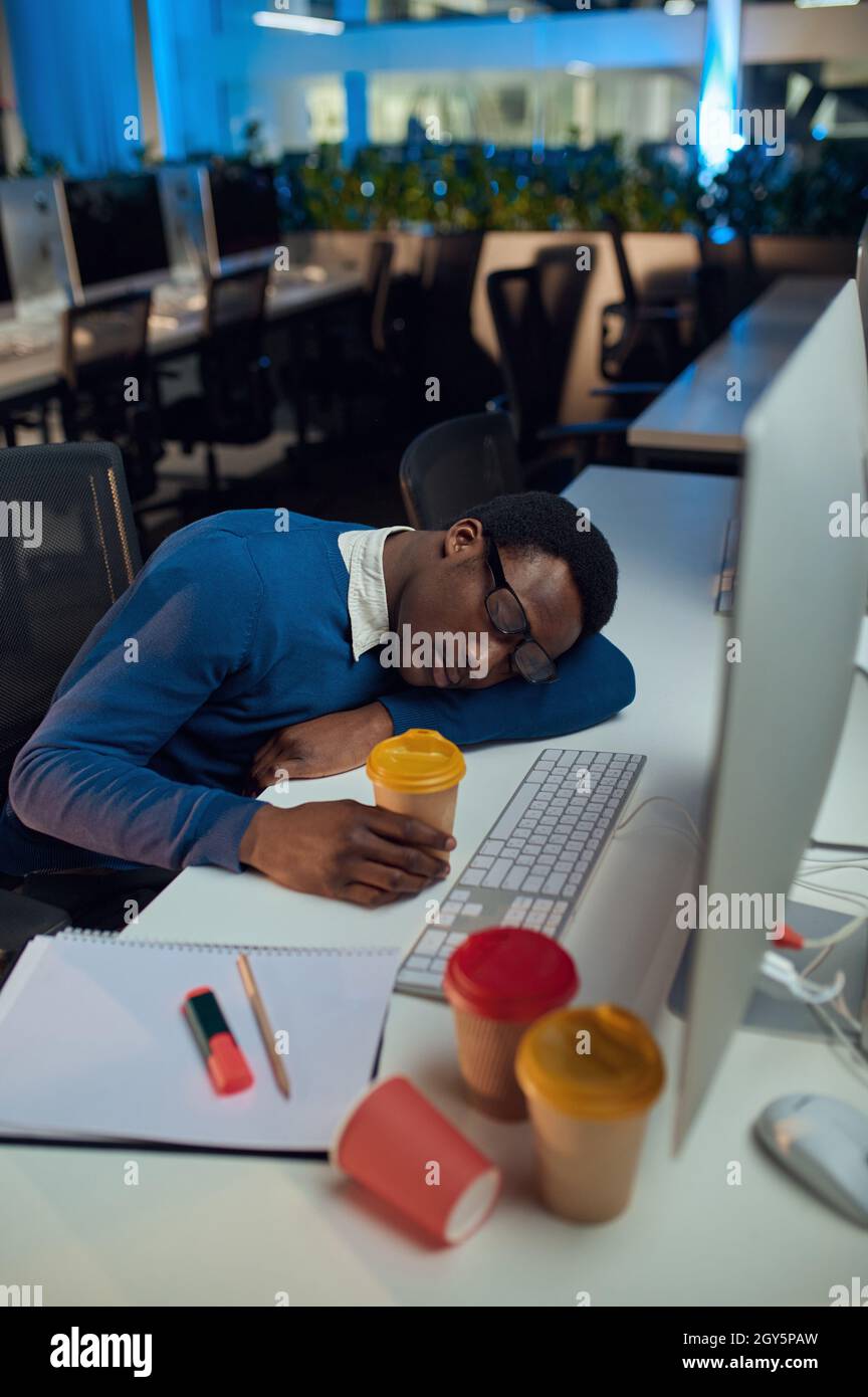 Manager sleeping at the table, night office lifestyle. Male person at ...