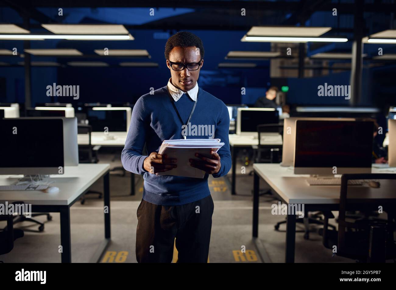 Manager looks in notebook, night office lifestyle. Male person the ...