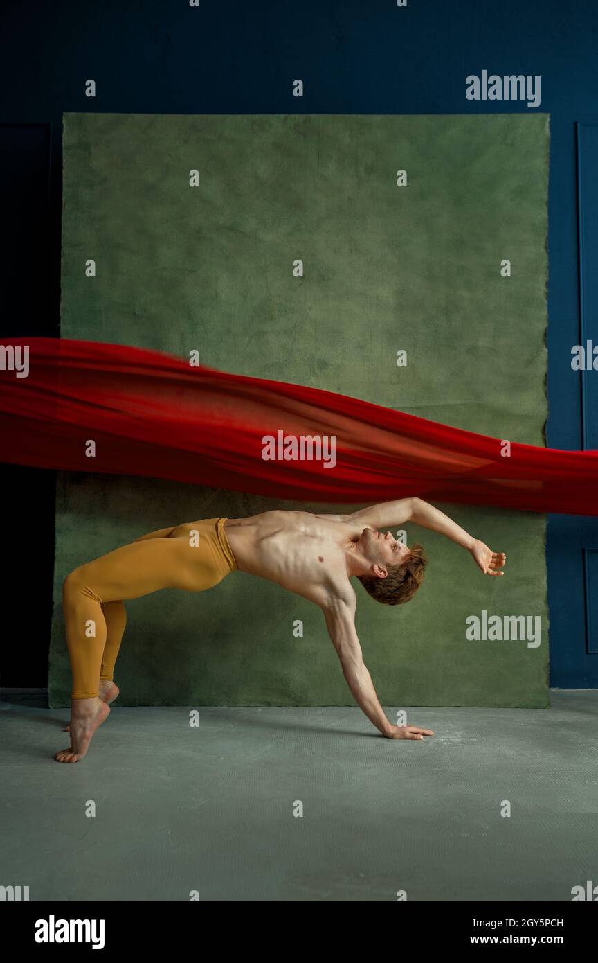 Male ballet dancer doing exercise in dancing studio, grunge wall and ...