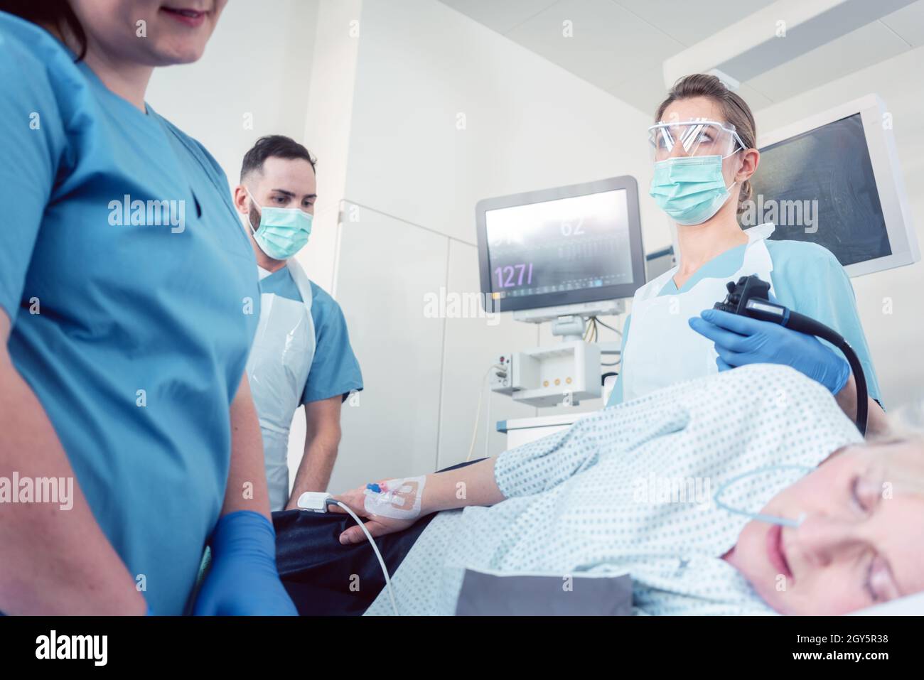 Doctor during colonoscopy in hospital looking at screen at picture from ...