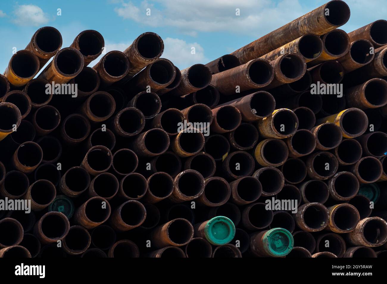 Pile of old rusty round metal industrial pipe. Steel pipe stack at ...