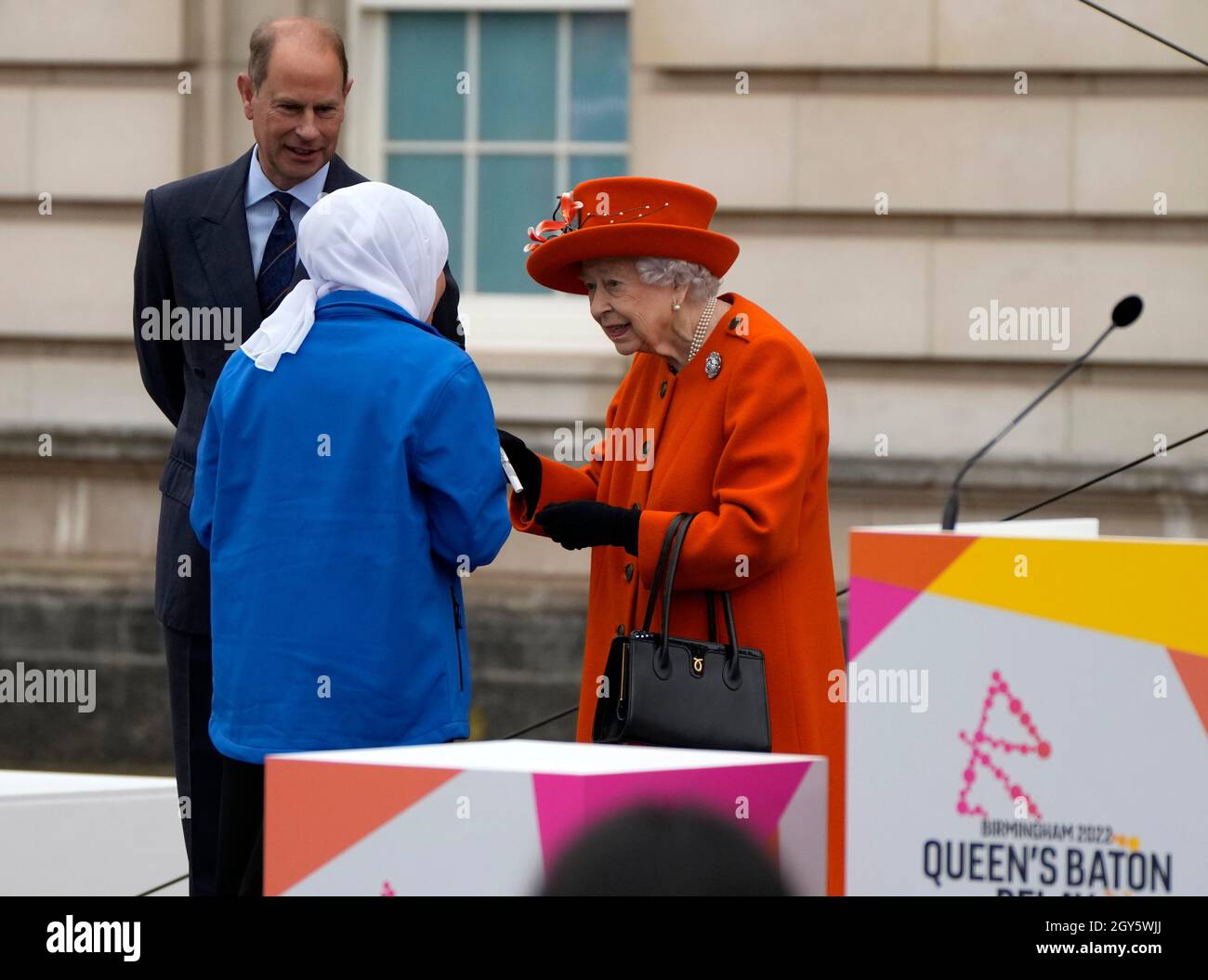 Queen Elizabeth II holds a message to be put inside the Queen's Baton ...