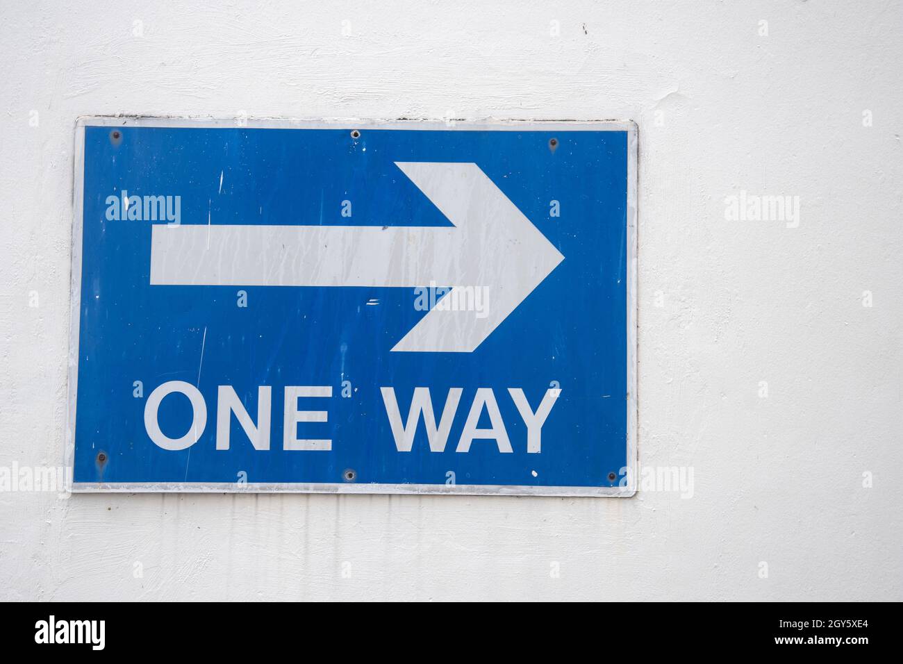 One way right arrow sign on the wall. White on blue background Stock ...