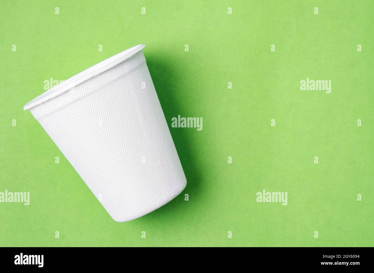Disposable paper drink glass on green background Stock Photo - Alamy