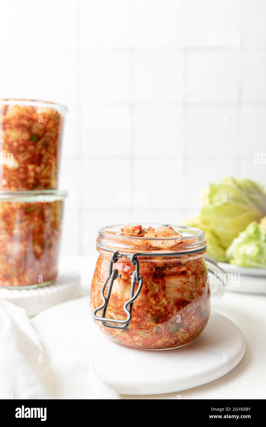 Traditional fermented cabbage kimchi in jars on a bright kitchen ...