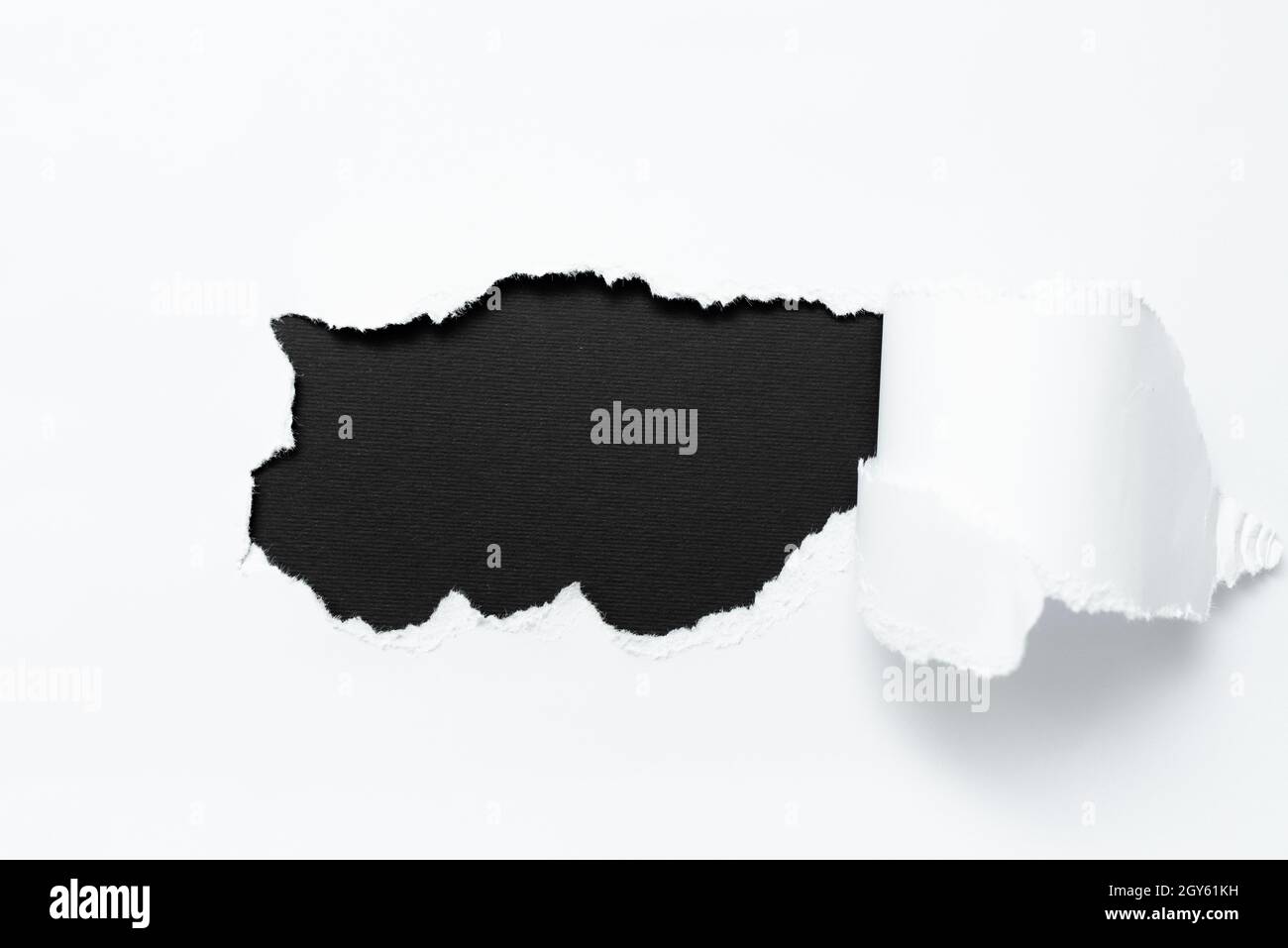 Tear on sheet reveals background behind the front side Stock Photo - Alamy