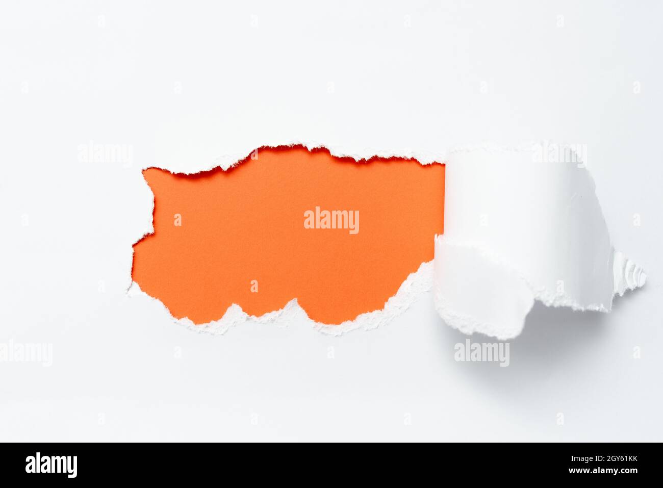 Tear on sheet reveals background behind the front side Stock Photo - Alamy