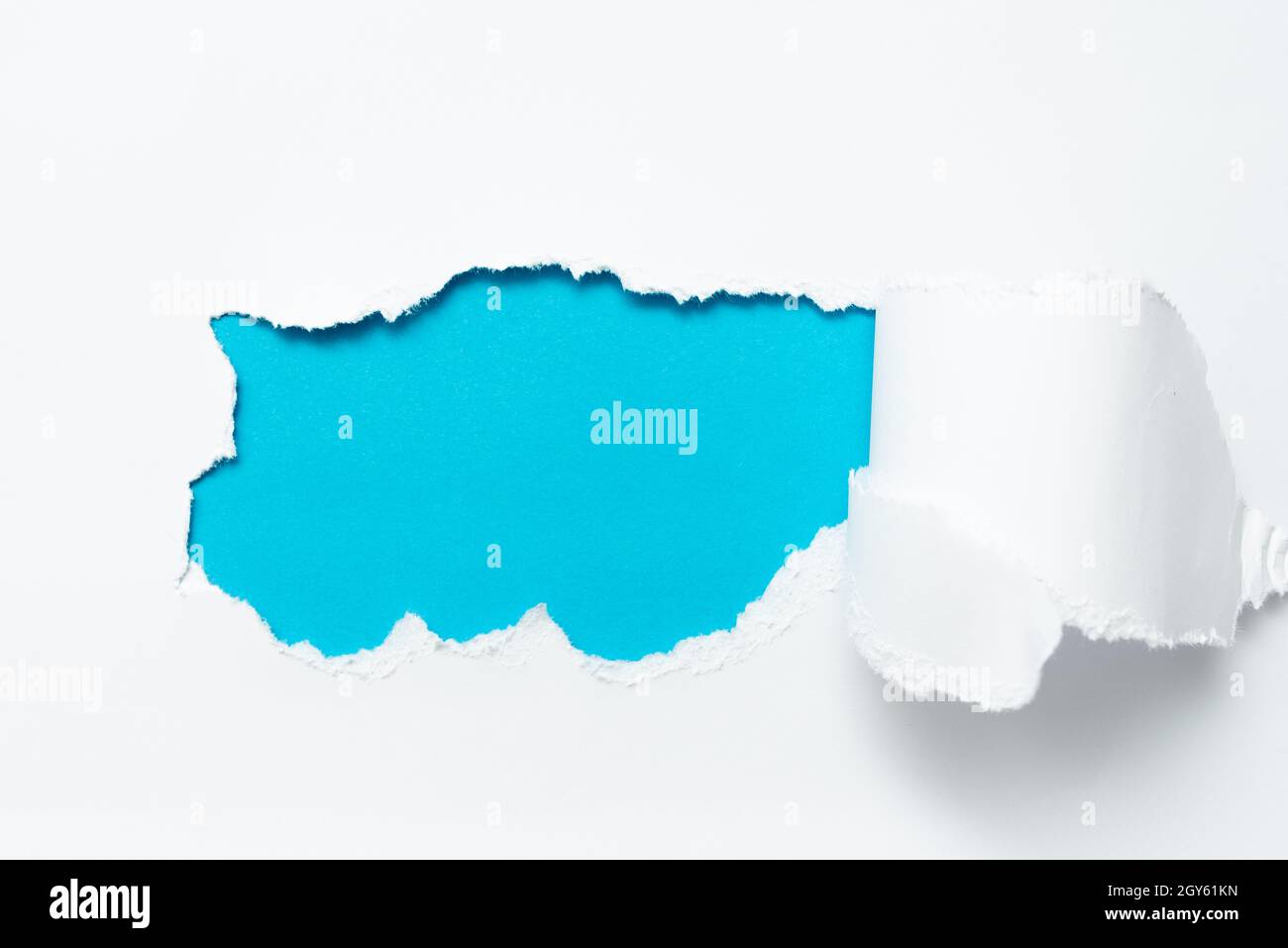 Tear on sheet reveals background behind the front side Stock Photo - Alamy