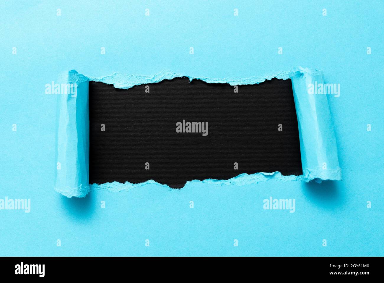 Tear on sheet reveals background behind the front side Stock Photo - Alamy