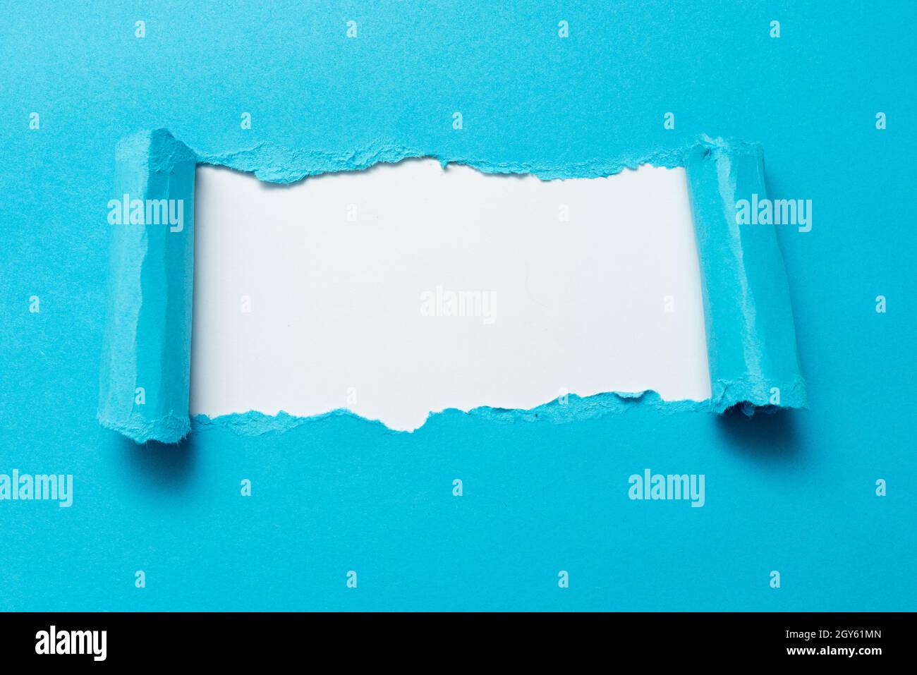 Tear on sheet reveals background behind the front side Stock Photo - Alamy