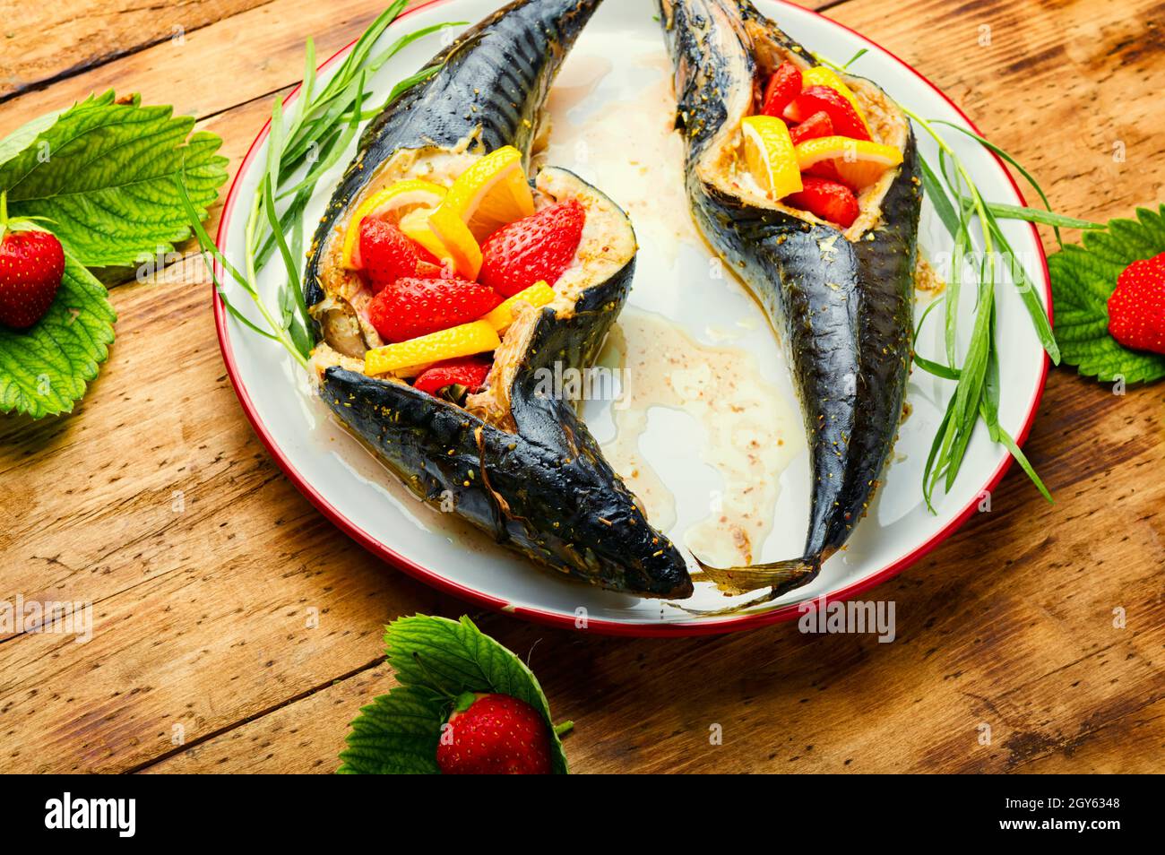 Fish baked with strawberry and lemon in the plate.Summer fish dish ...