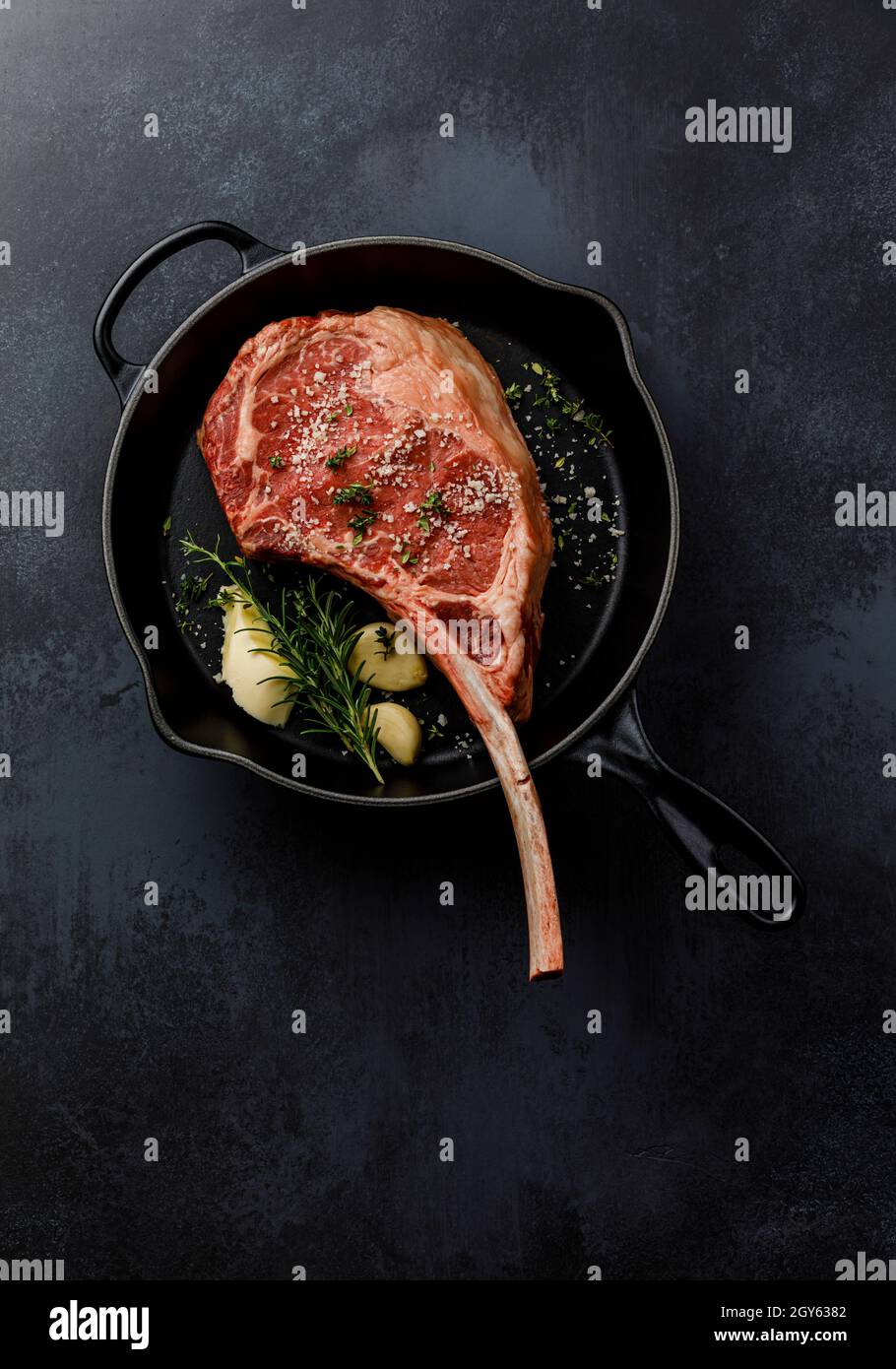 Raw fresh meat Tomahawk Steak in Cast iron frying pan on dark ...