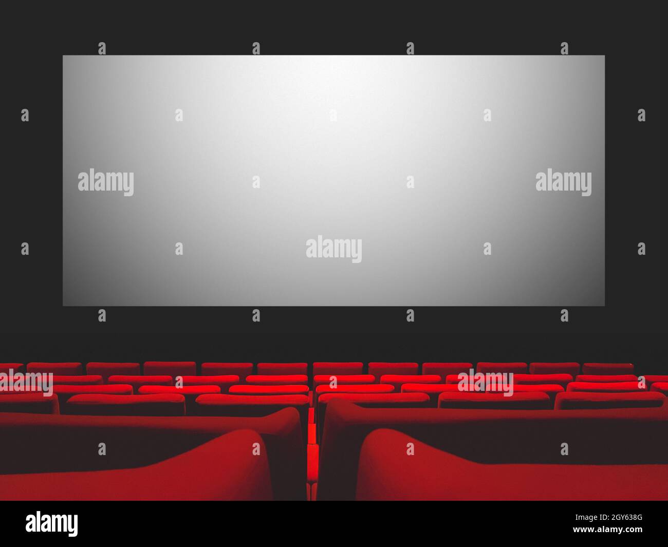 Cinema movie theatre with red velvet seats and a blank white screen ...