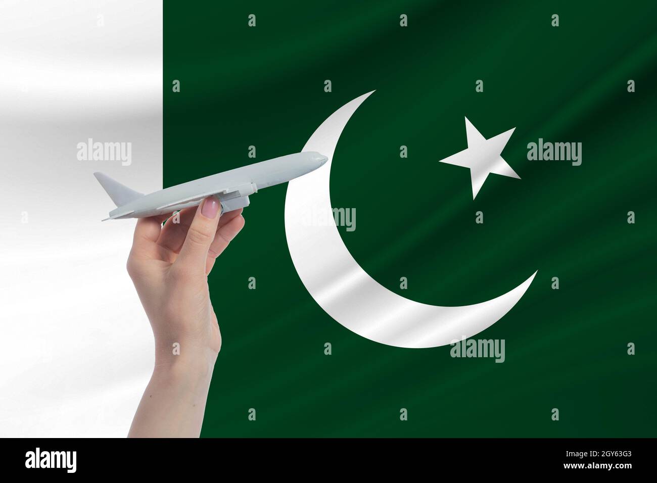 Airplane in hand with national flag of Pakistan. Travel to Pakistan ...