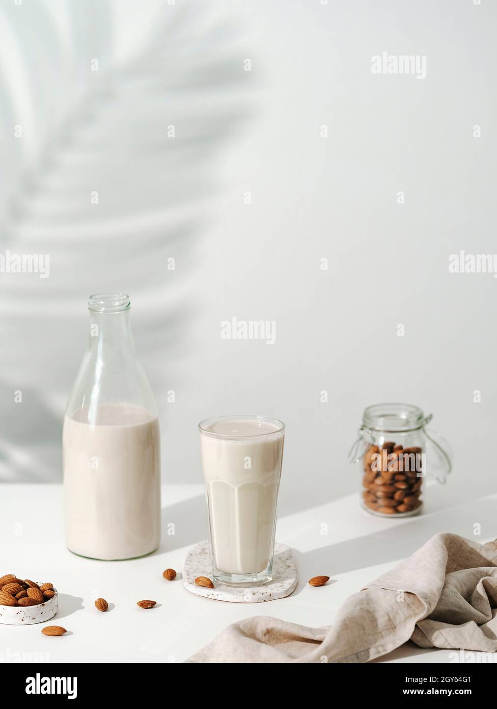 Almond vegan milk on the table, copy space. Vertical. Modern light ...