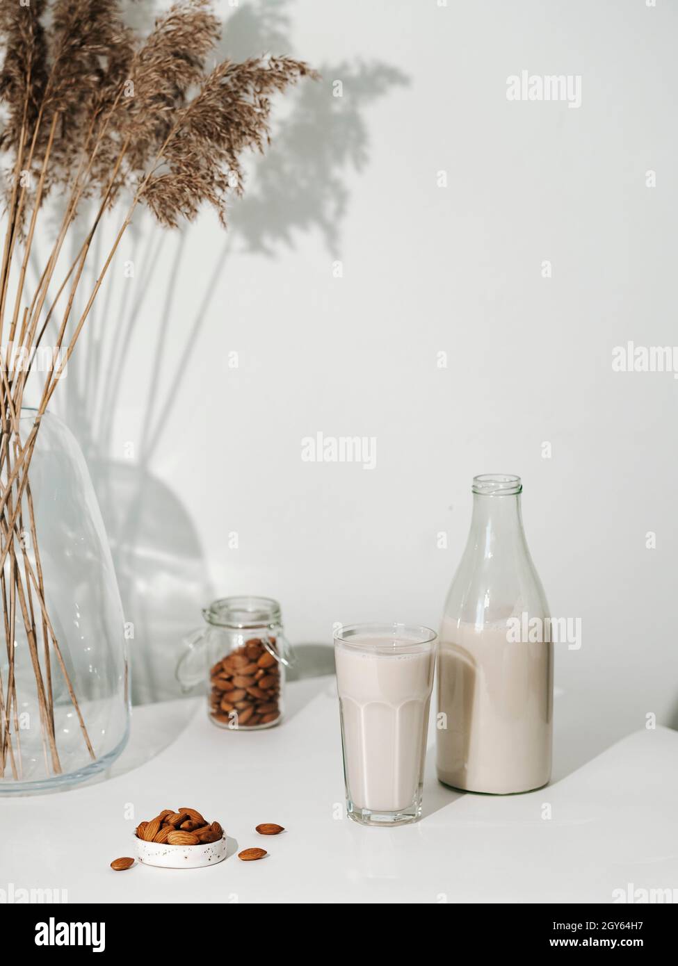 Almond vegan milk on the table, copy space. Vertical. Modern light ...
