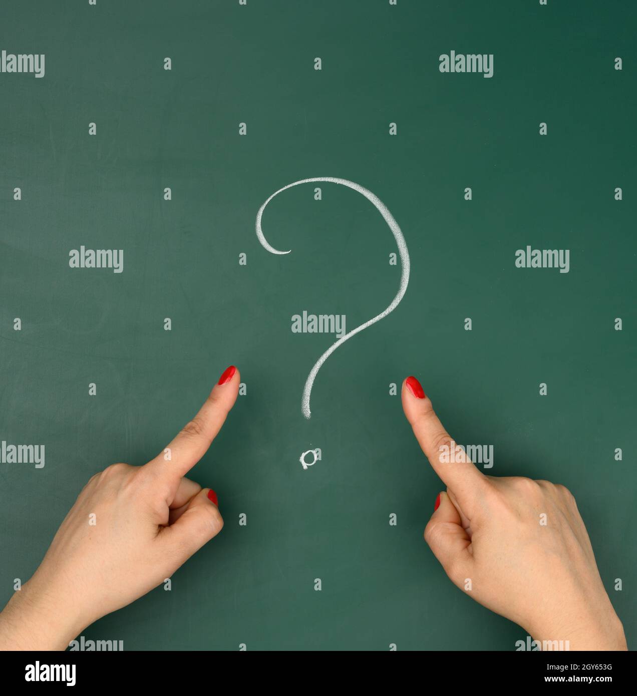 a question mark drawn in white chalk and female hands point a finger at ...