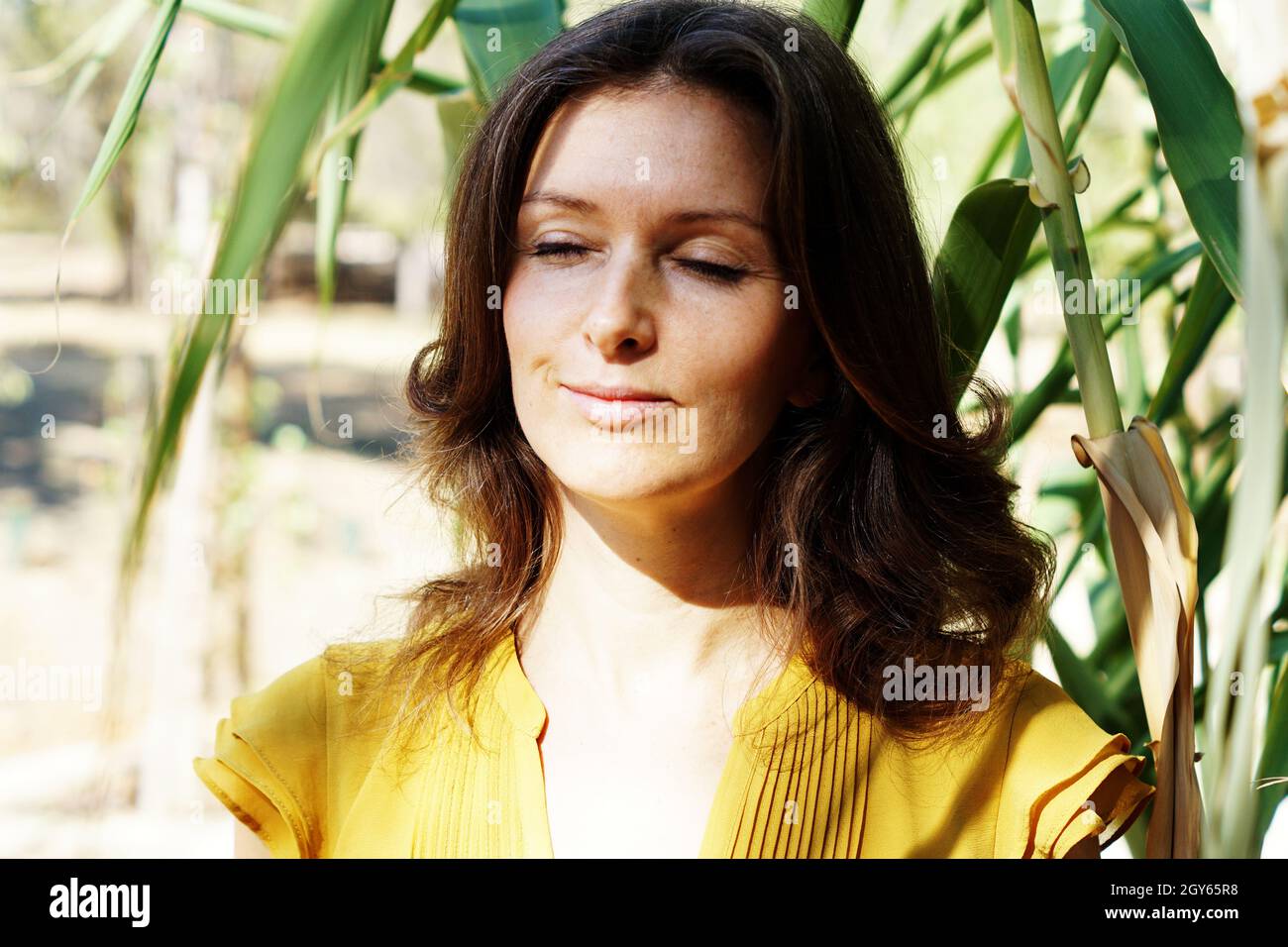 Portrait of a pretty Spanish woman in a yellow dress posing in a ...