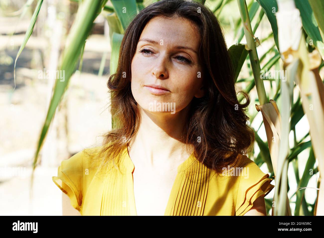 Portrait of a pretty Spanish woman in a yellow dress posing in a ...