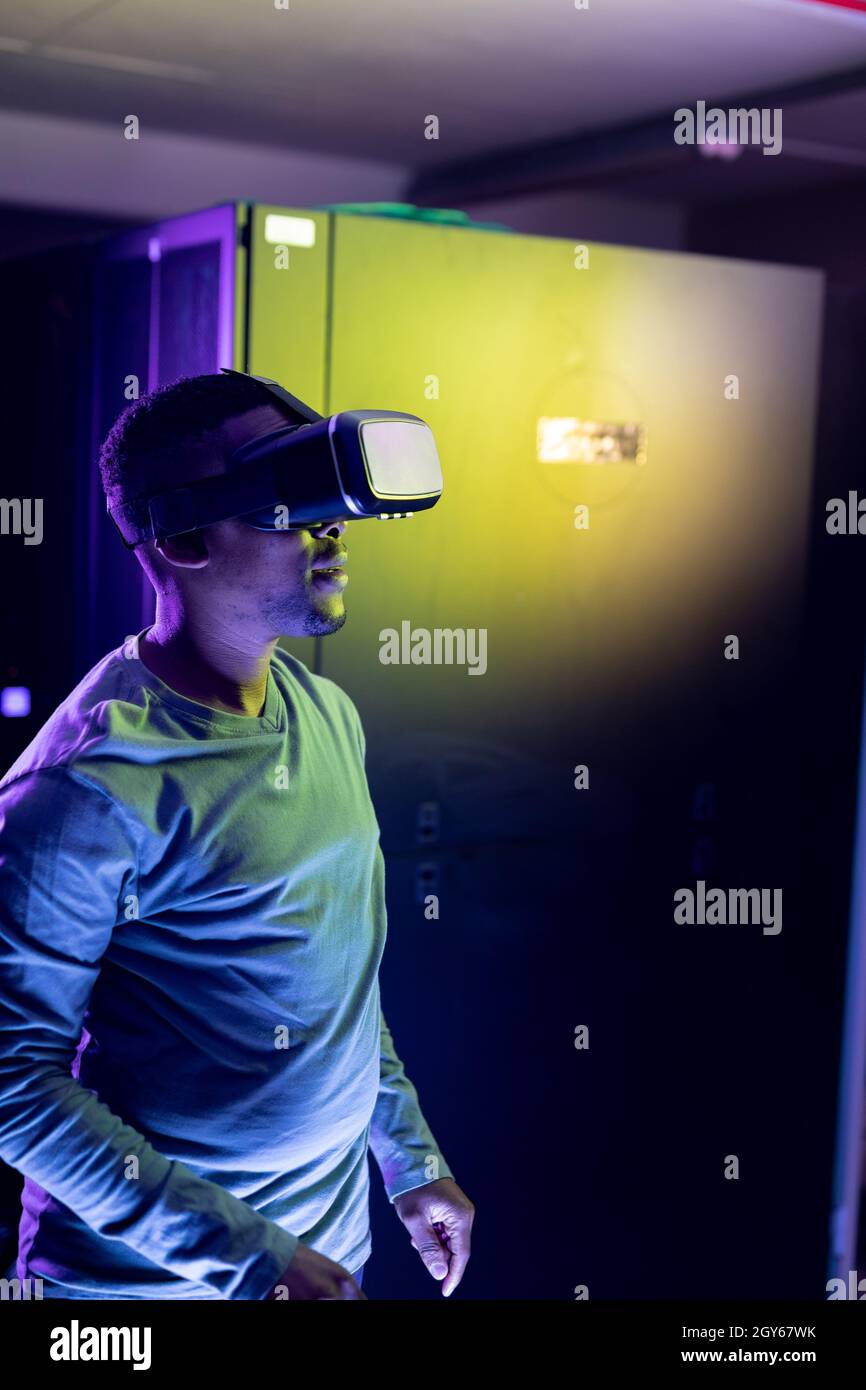 African american male computer technician wearing vr headset and ...