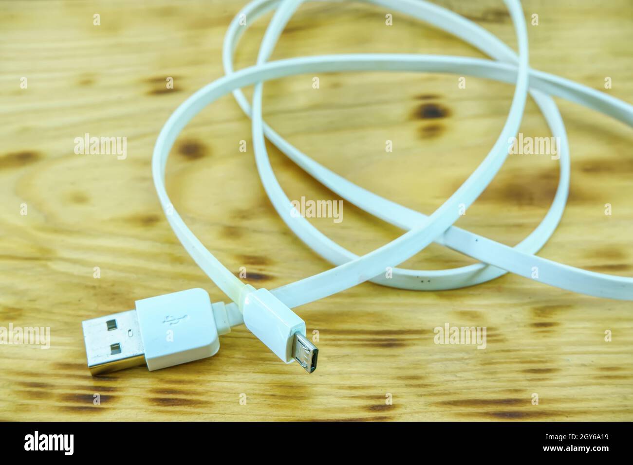 Electrical charging devices for mobile telephone on a wooden background ...
