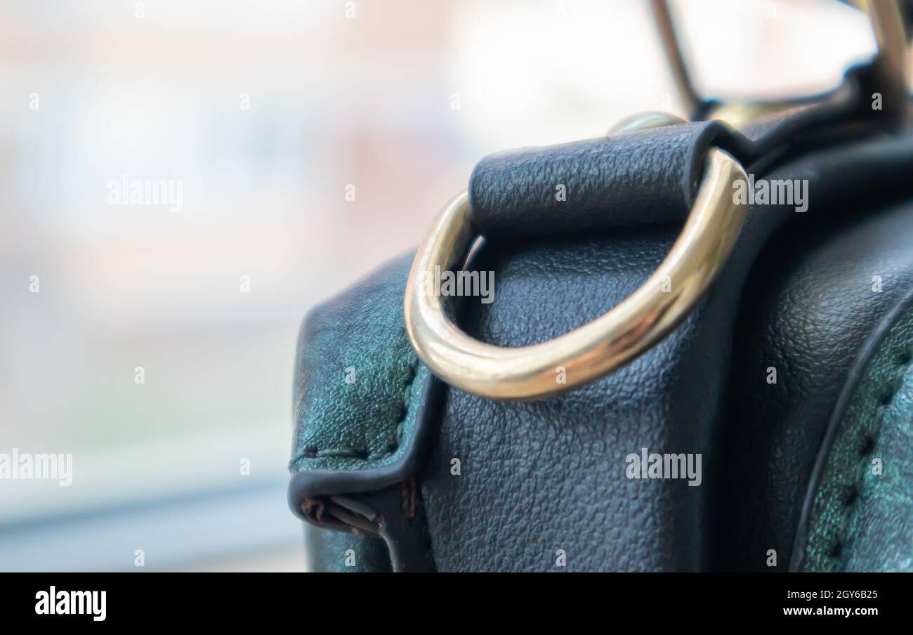 Metal gold loop oval ring attached to a leather bag. Selective focus ...