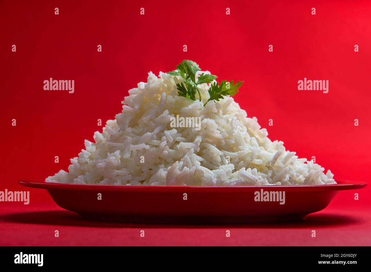 Cooked plain white basmati rice in a red plate on red background Stock ...