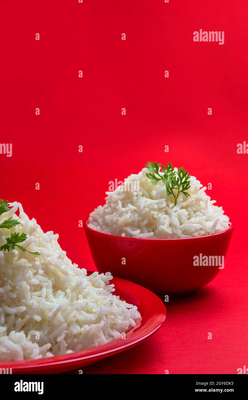 Cooked plain white basmati rice in bowl and plate on red background ...