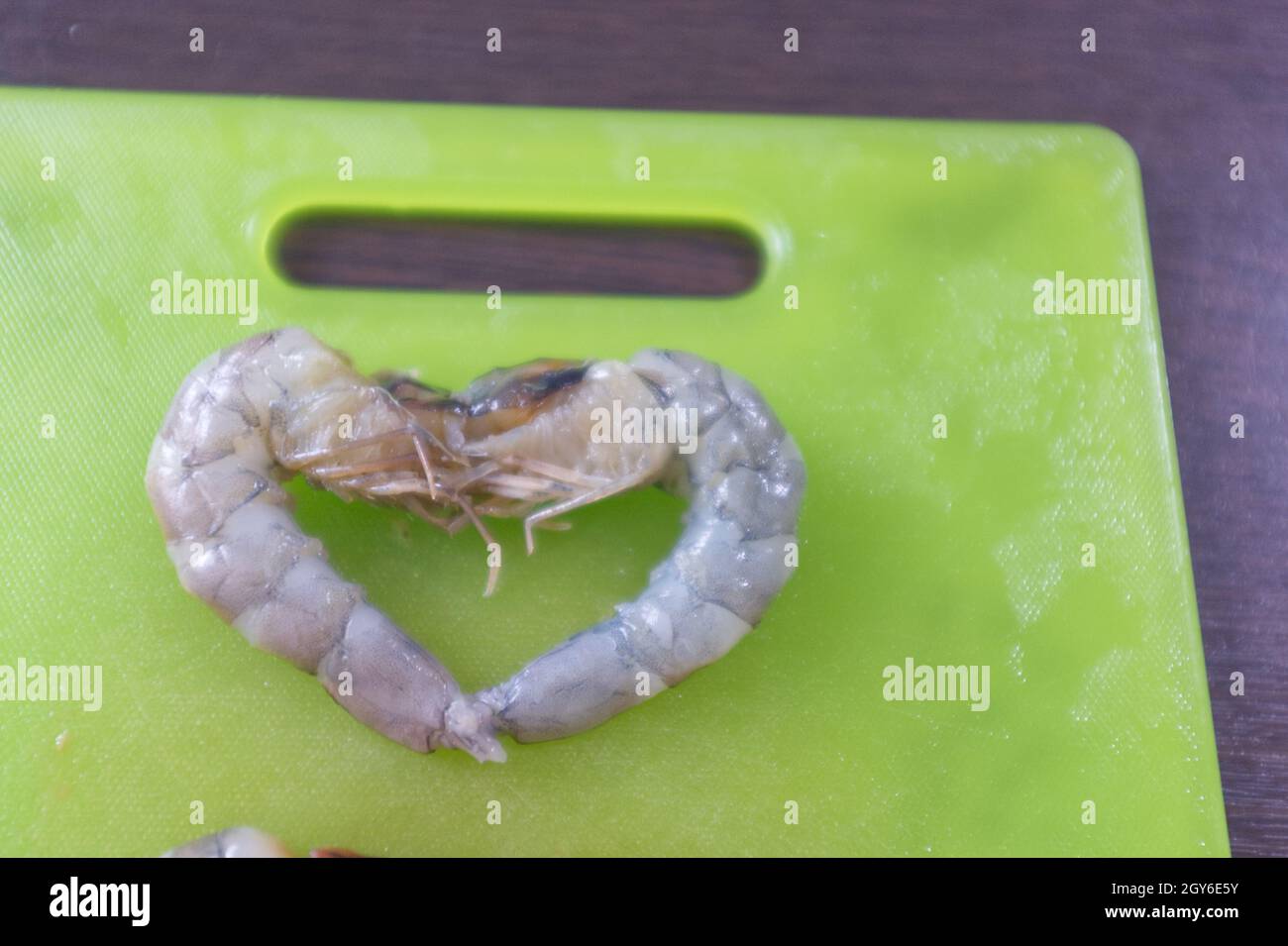prawn in heart shape isolated on green background Stock Photo - Alamy
