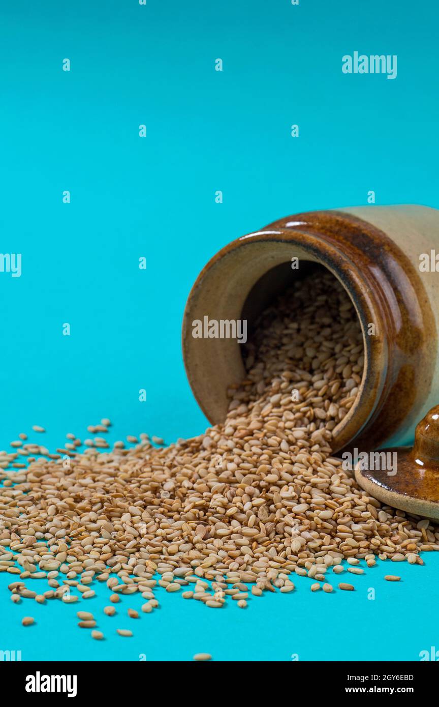 Sesame Seeds in pot on blue background Stock Photo - Alamy